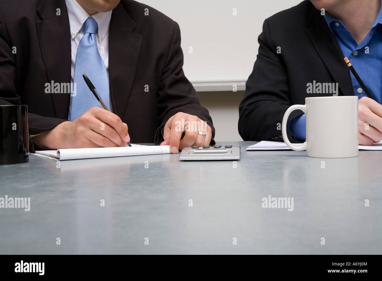 Two businessmen working at a table Stock Photo - Alamy