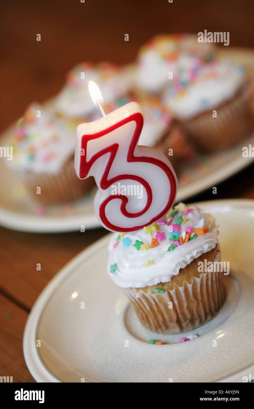 Decorated cupcake with a lit candle Stock Photo - Alamy