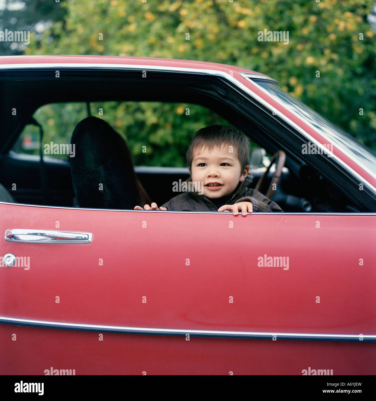 Young boy sitting in a car Stock Photo - Alamy