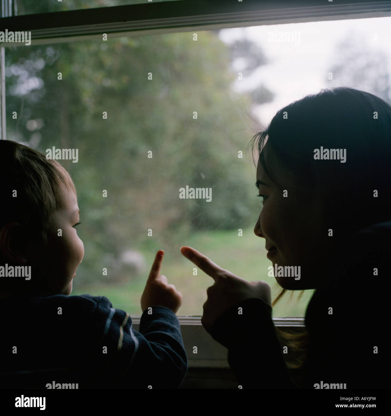 Mother and son pointing out of the window Stock Photo - Alamy
