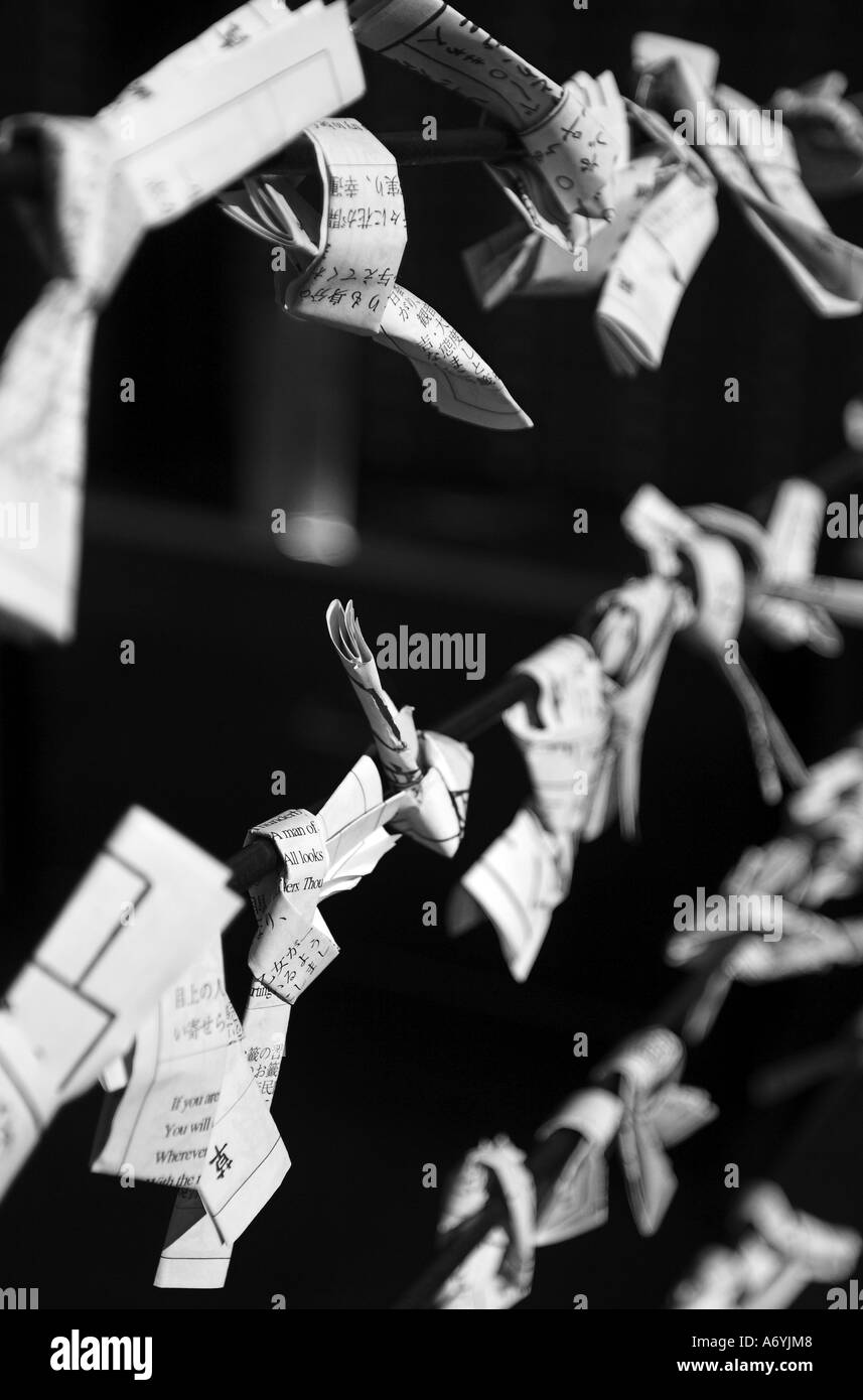 Portrait format image of Japanese fortune papers attached to a wire in ...