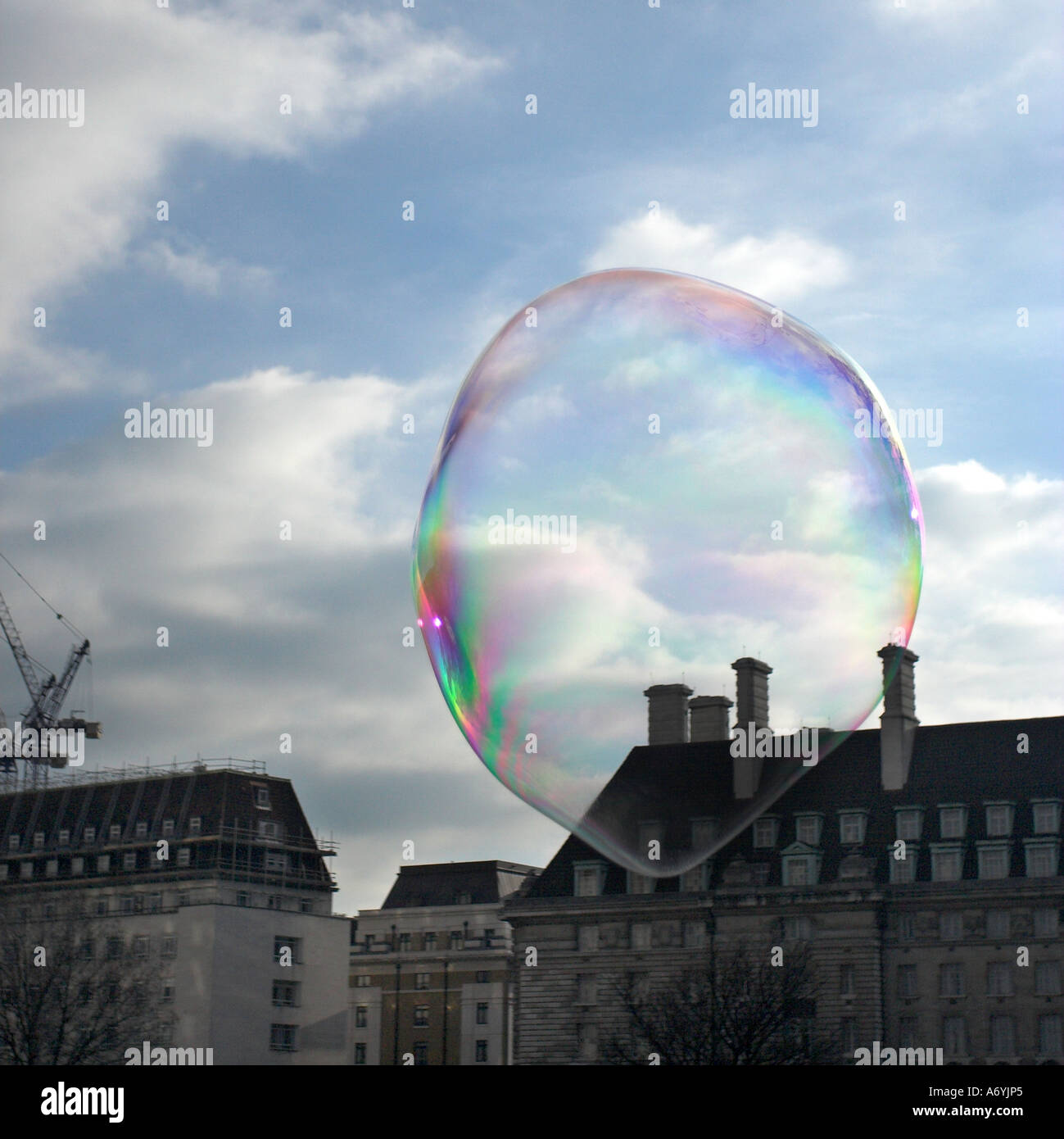 Square format image of a large soap bubble with buildings and sky in ...