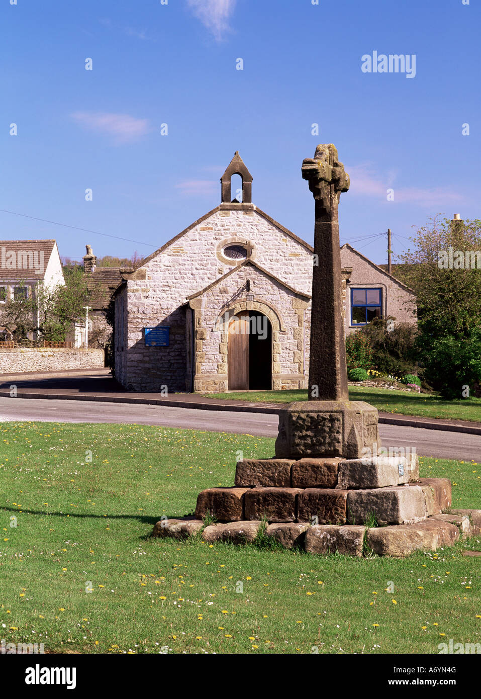 14th century village cross in front of the church of St Hugh Foolow ...