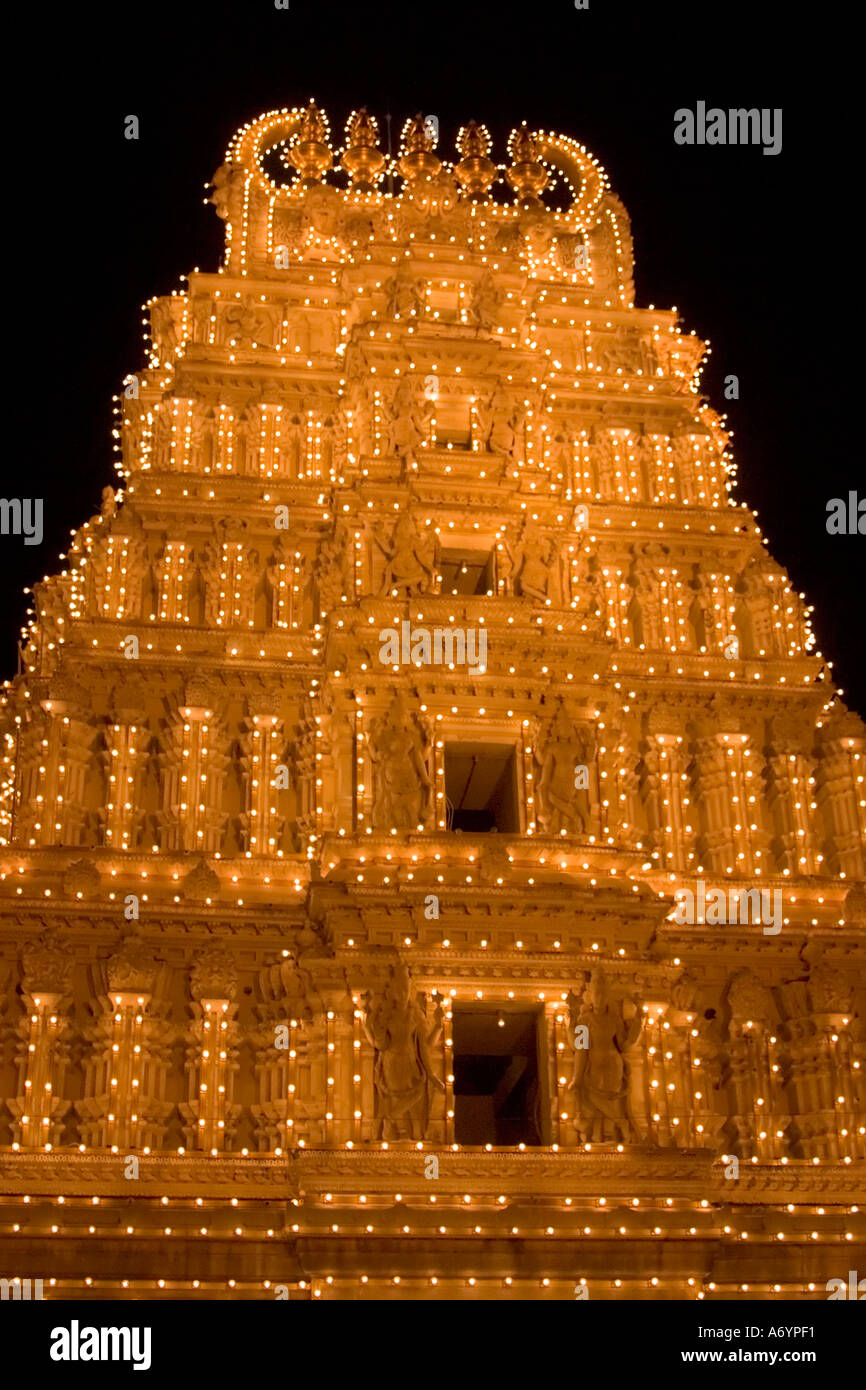 A temple tower is lit by hundreds of light bulbs against a black night ...