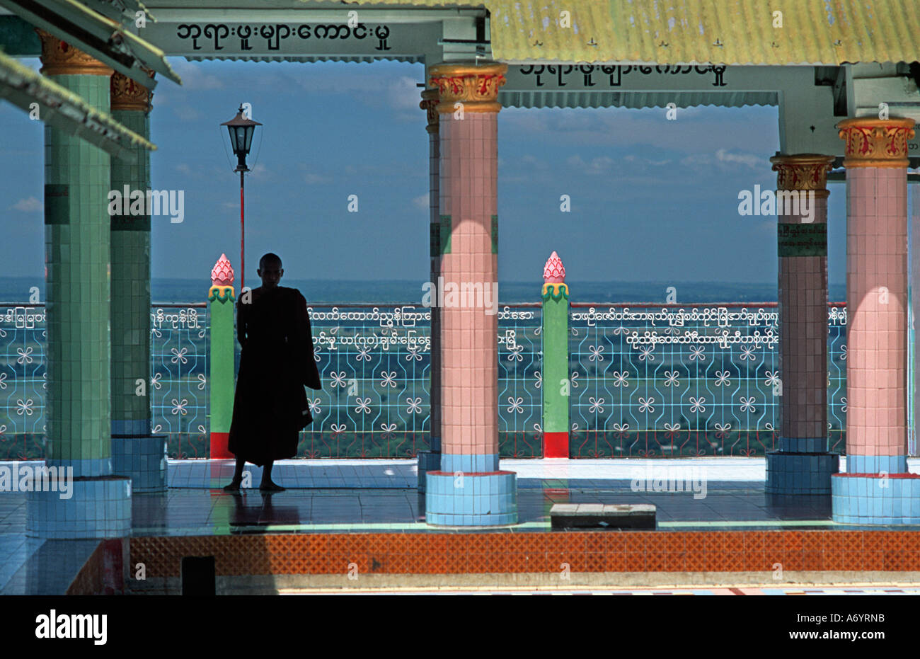 A robed monk against the colourful surroundings at Sagaing widely ...