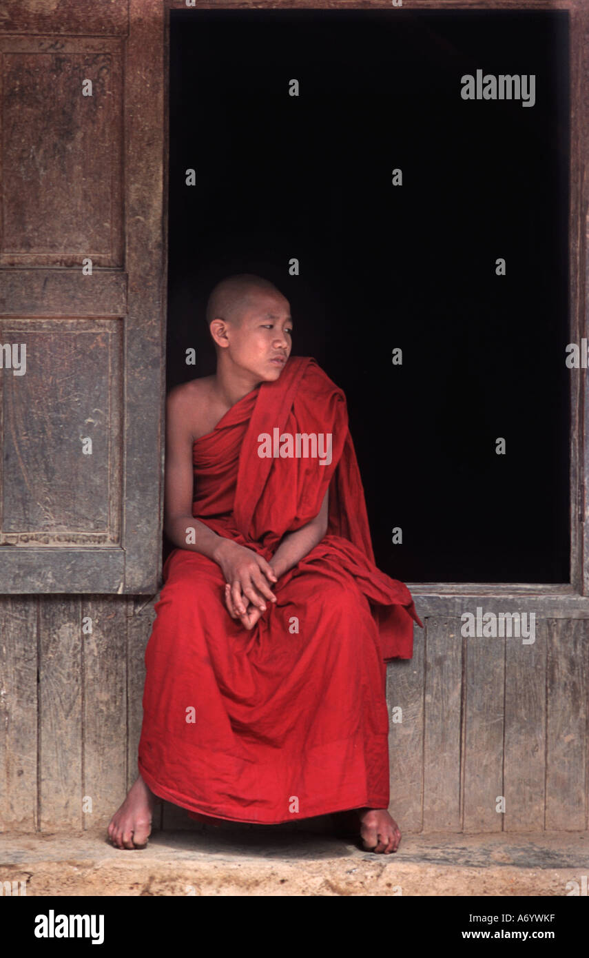 Novice monk sitting on a window sill outside the rural monastery in ...