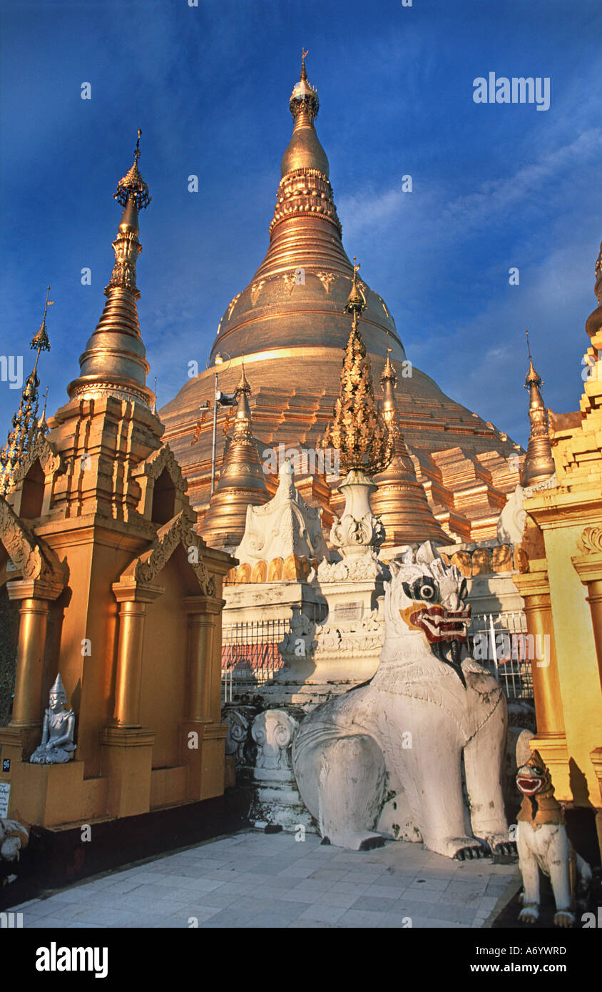 Golden sunlight illuminates the stupa and statues of Shwedagon Pagoda ...