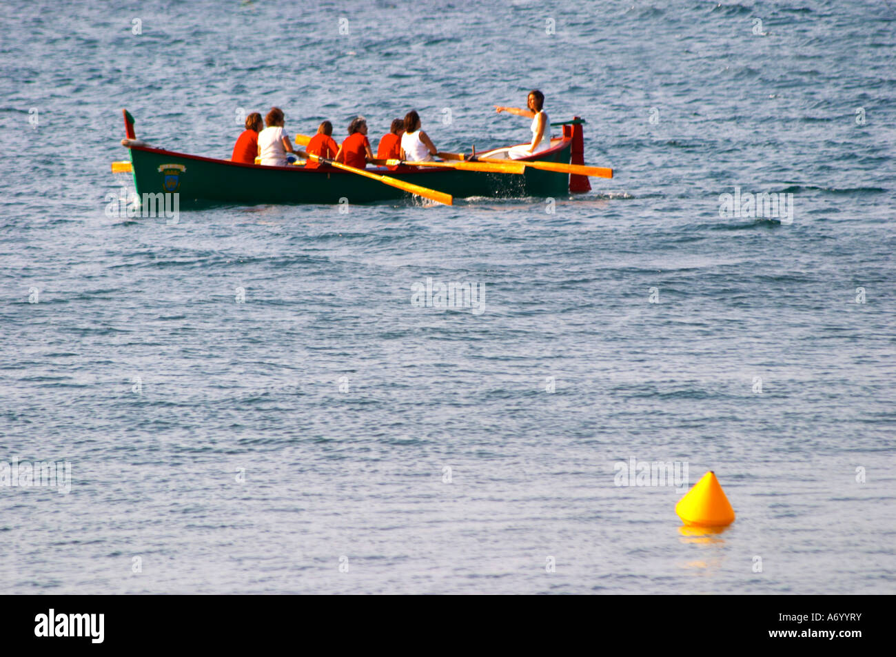 A group of women practicing rowing in an old fashioned rowing boat ...