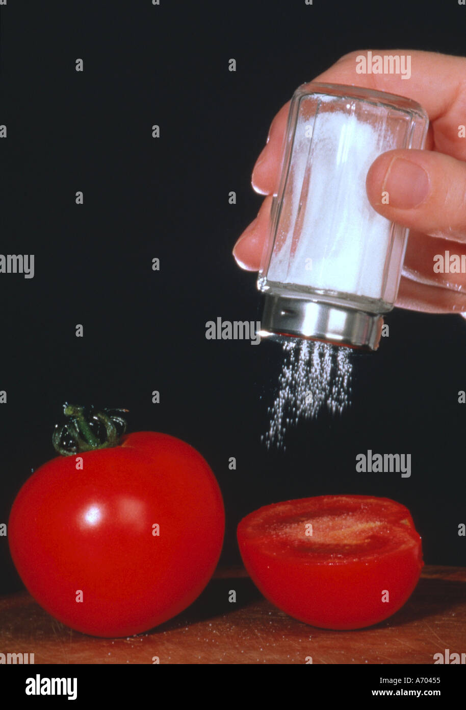 food spice salt hand with a saltshaker salting tomatoes Stock Photo - Alamy