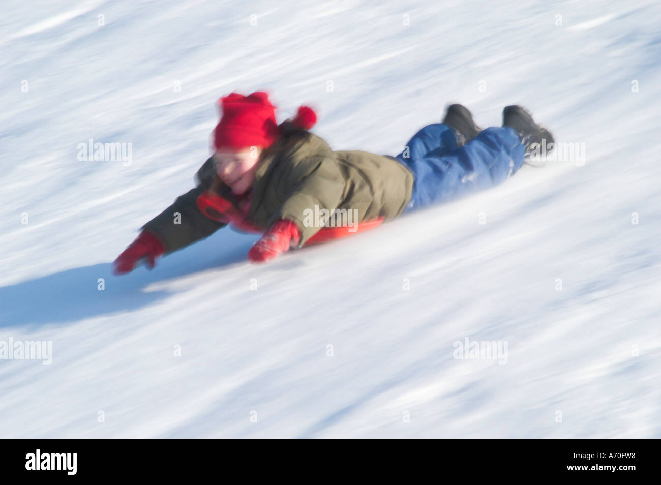 Girl sliding on her belly downhill Stock Photo - Alamy