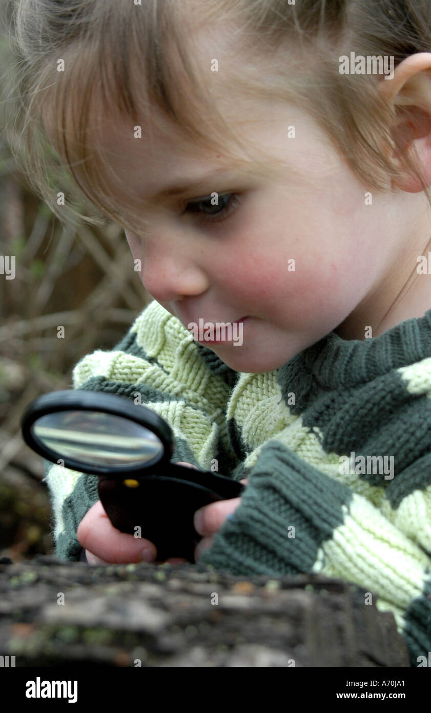 Child looking though magnifying glass Stock Photo - Alamy