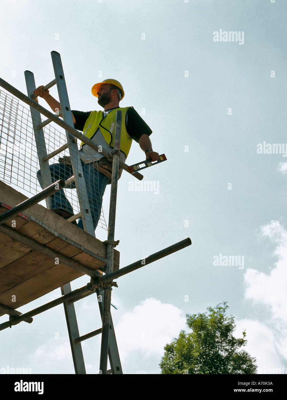 CONSTRUCTION WORKER ON LADDER BUILDING SITE UK Stock Photo - Alamy