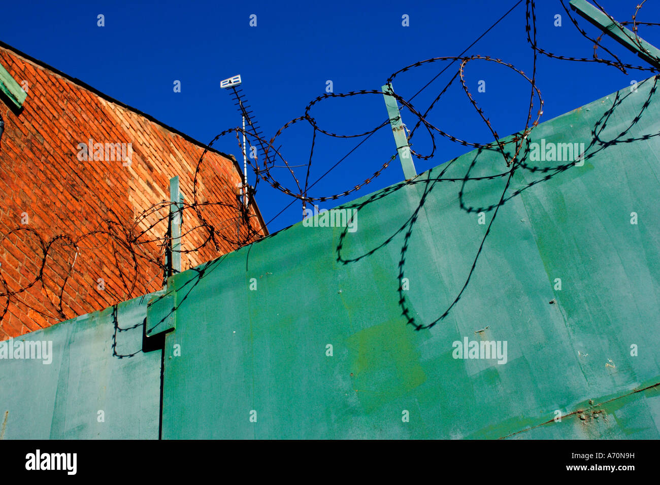 colorful security fence with razor wire Stock Photo - Alamy