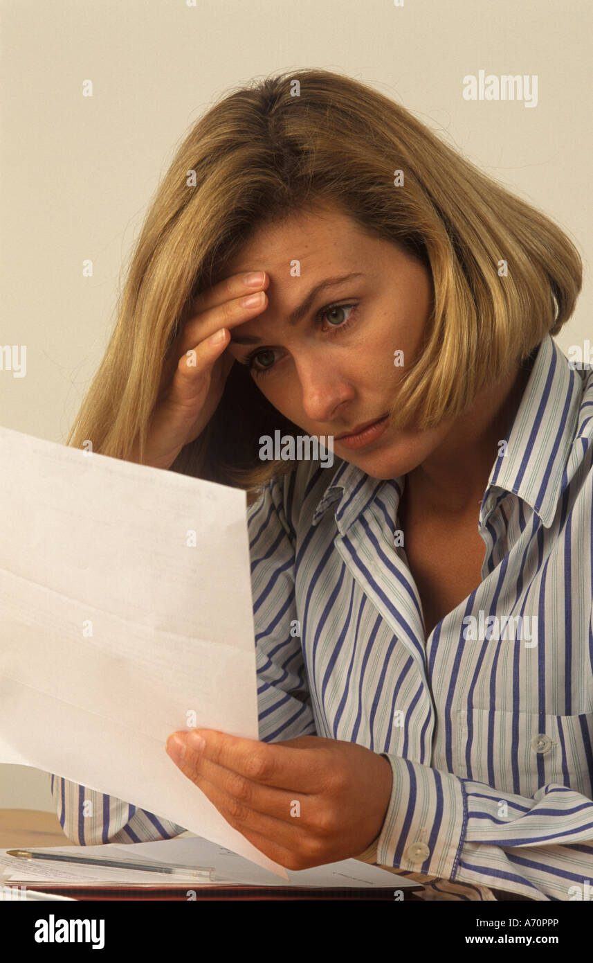 woman reading letter and looking worried Stock Photo - Alamy