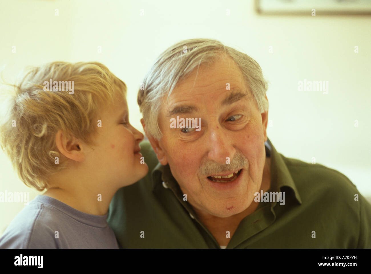 little boy whispering into his grandfather s ear Stock Photo - Alamy