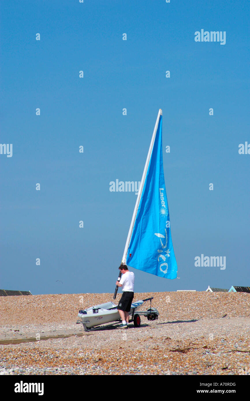 Man with sailing dinghy on beach at Goring-by-Sea, West Sussex, England ...