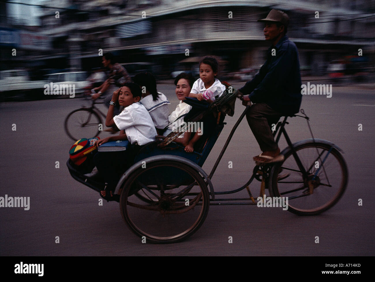 Cambodia Phnom Penh Blurred image of family riding in bicycle rickshaw ...