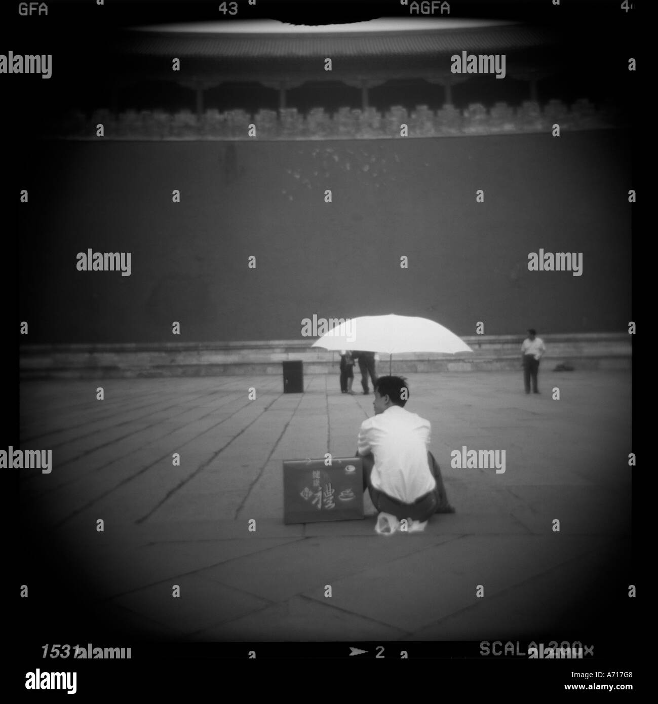 Asia China Beijing Man sitting under umbrella near Gate of Heavenly ...