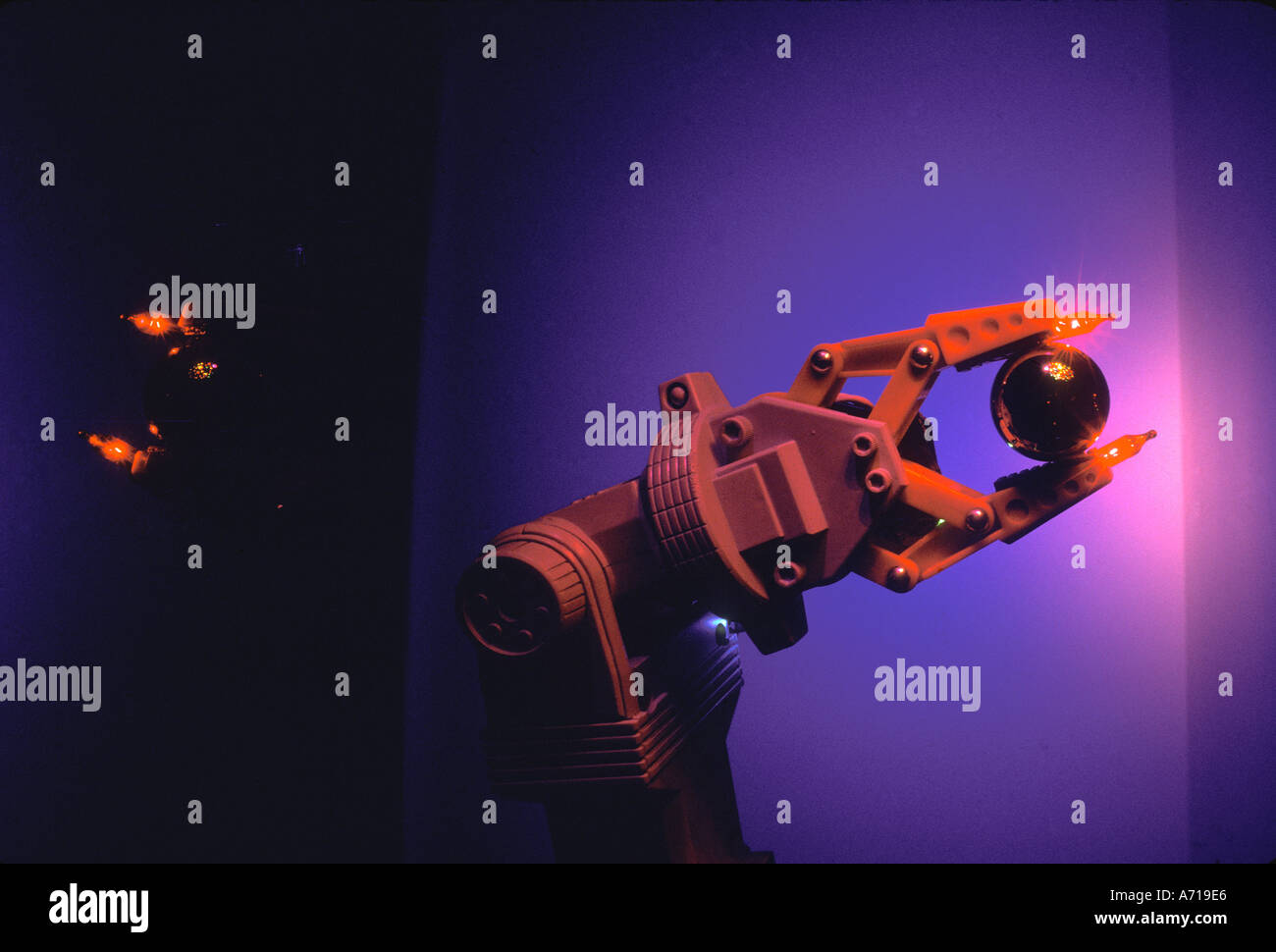 robotic arm holding black ball pink and blue lighting Stock Photo - Alamy