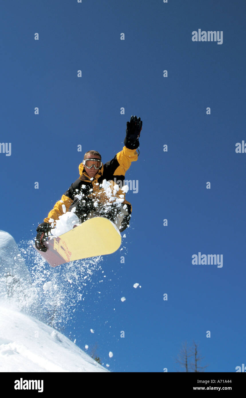Free riding snowboarder grab off a natural jump in the terrain Stock ...