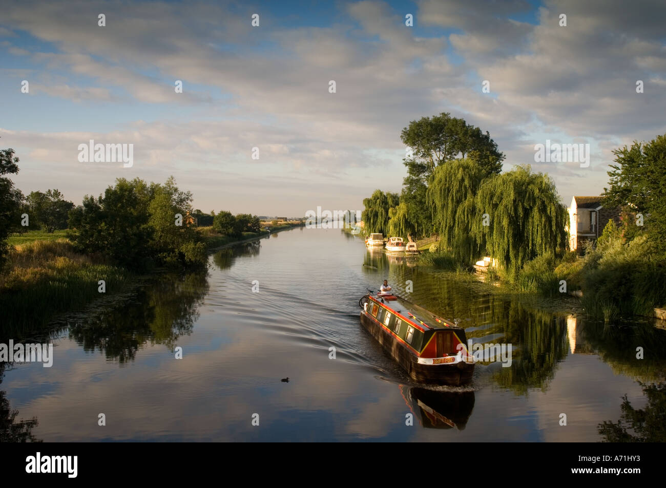 Long boat floating along the River Ouse in the fens at Littleport ...