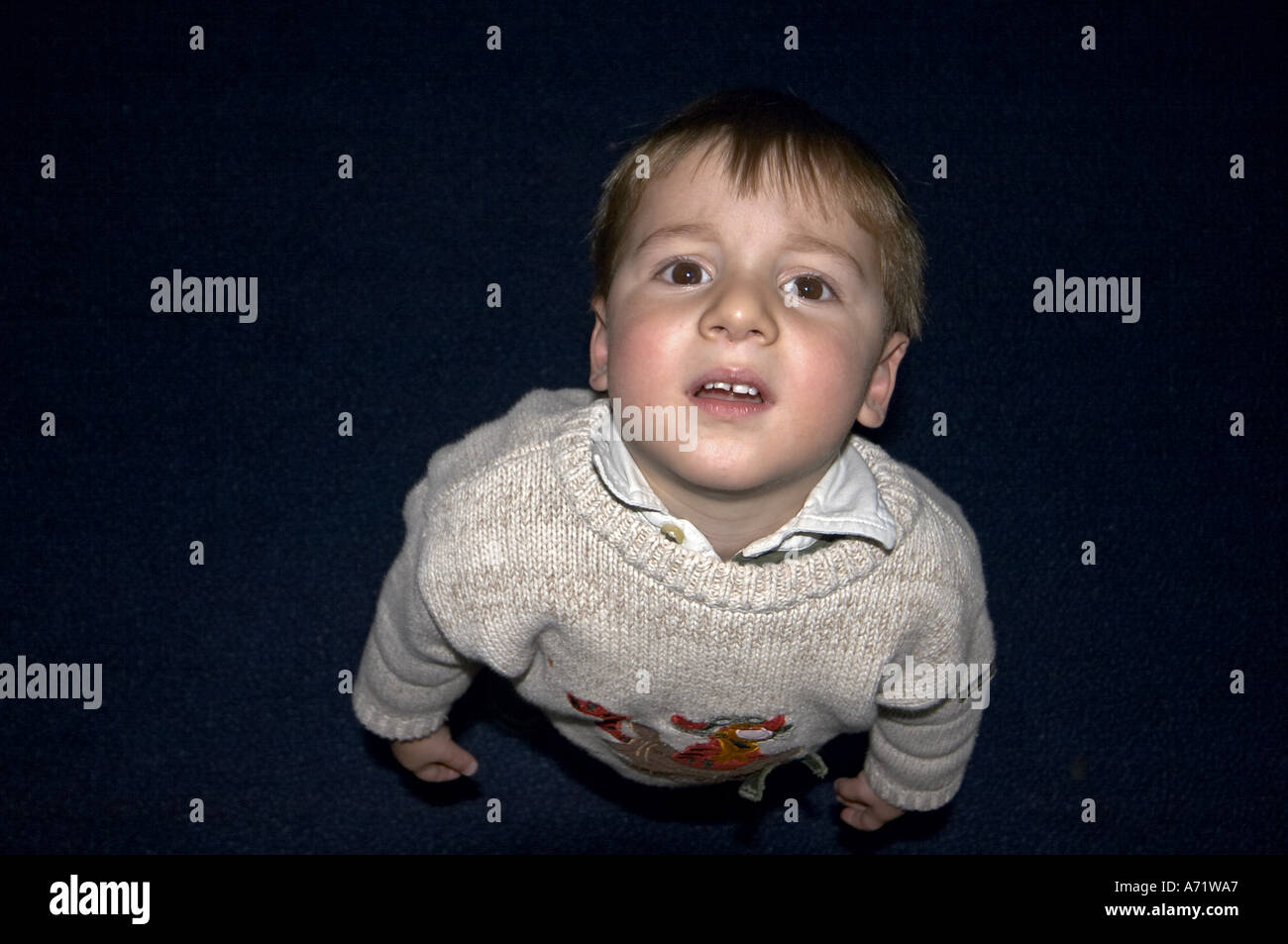 Young boy with his head back looking at the camera above with black ...