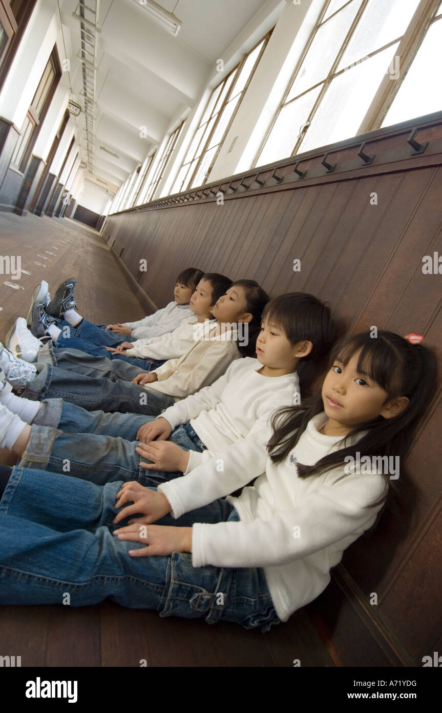 Children sitting in corridor Stock Photo - Alamy