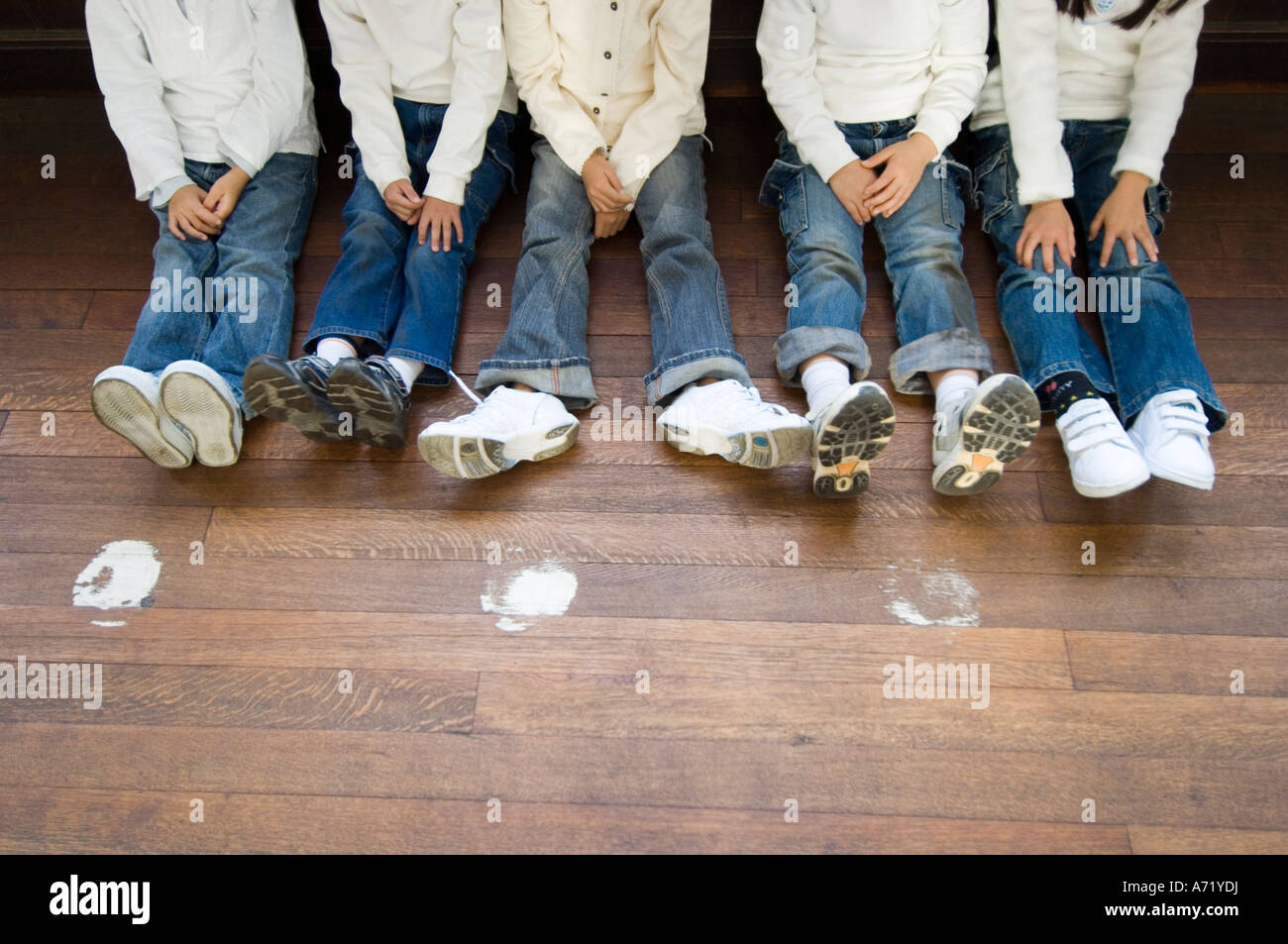 Legs of children sitting in corridor Stock Photo - Alamy