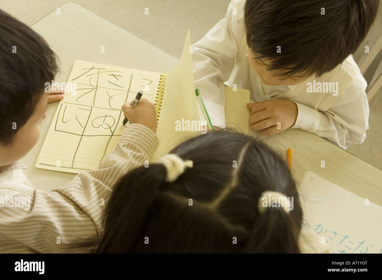 Children writing on notebook Stock Photo - Alamy