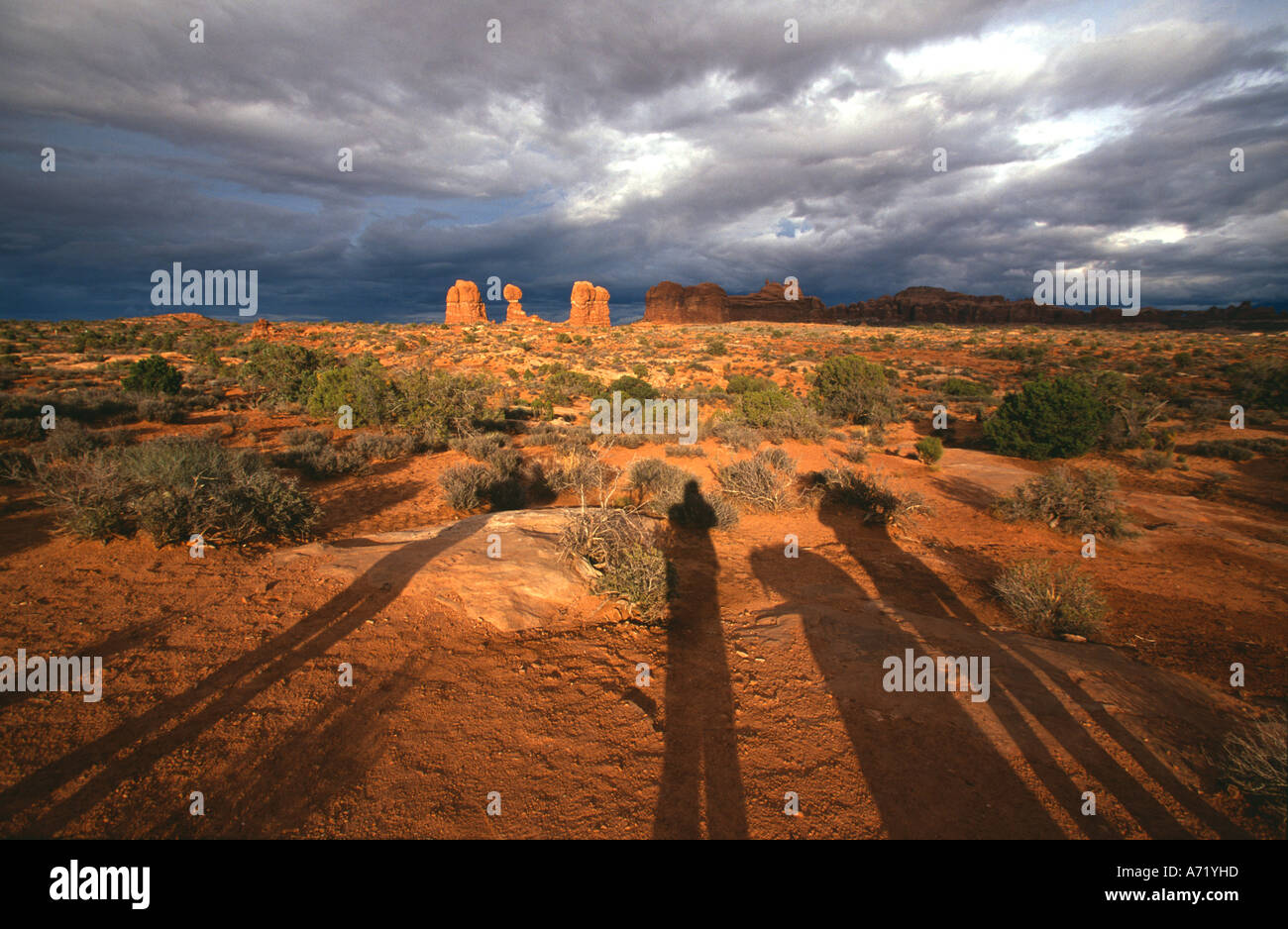 Shadows of people watching sunset light effects on rock formations in ...