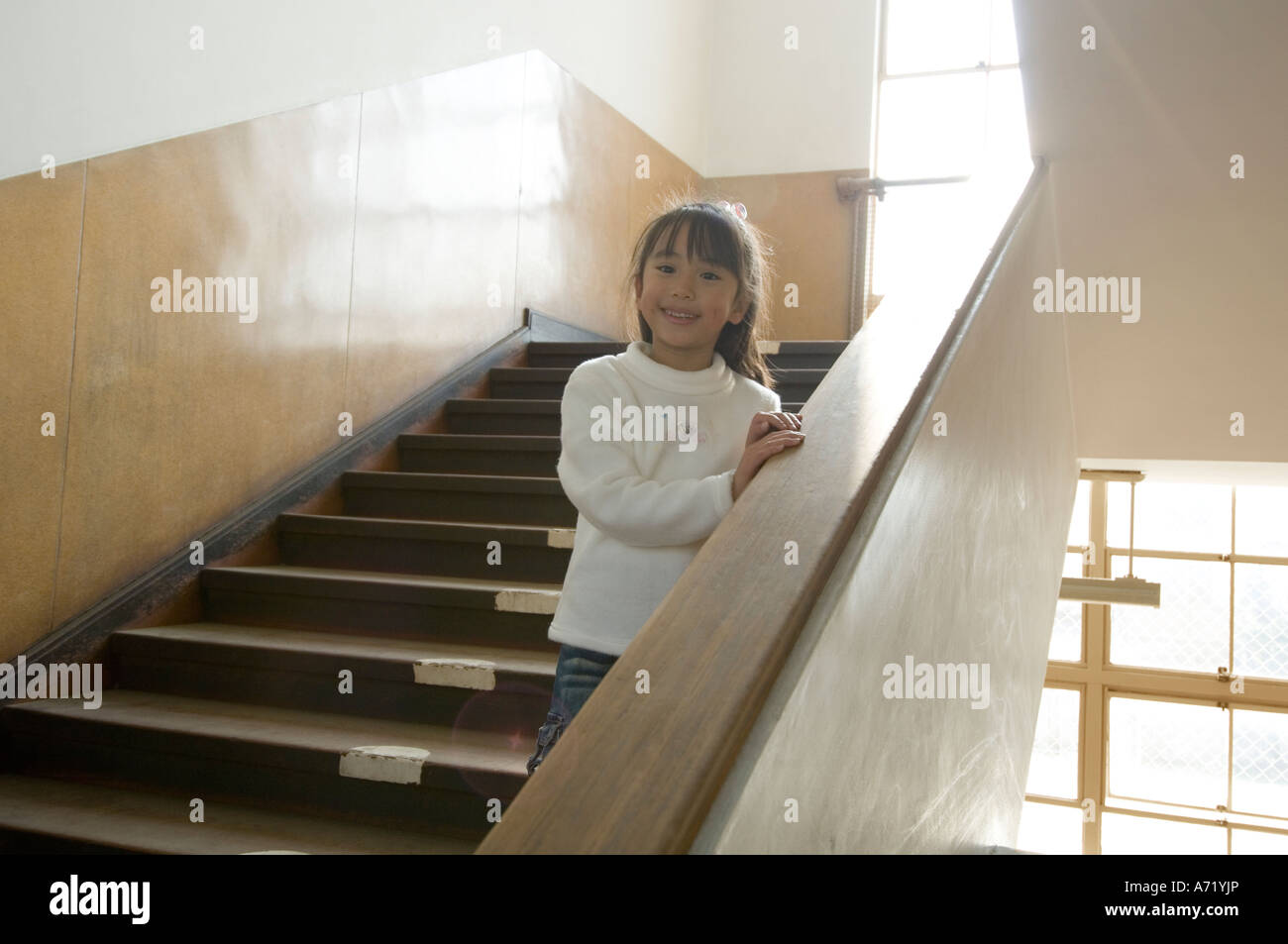 Girl standing on staircase Stock Photo - Alamy