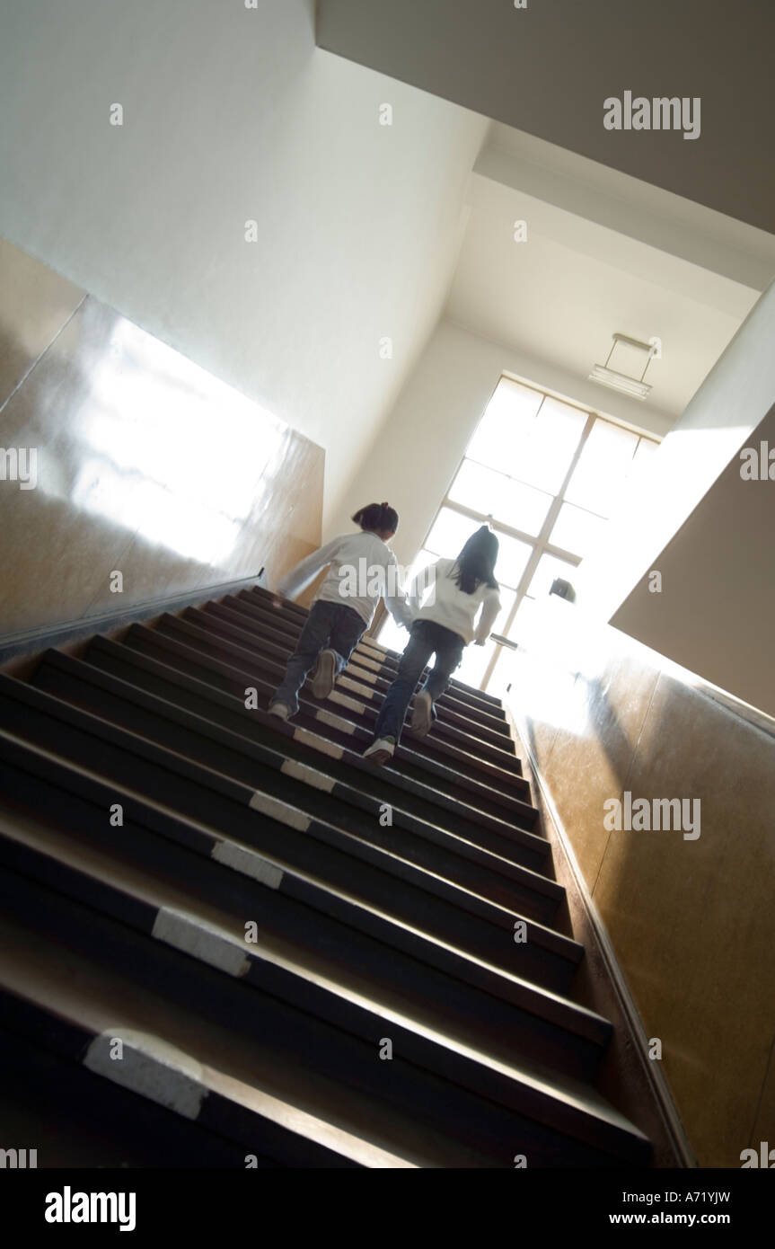 Children moving up staircase Stock Photo - Alamy