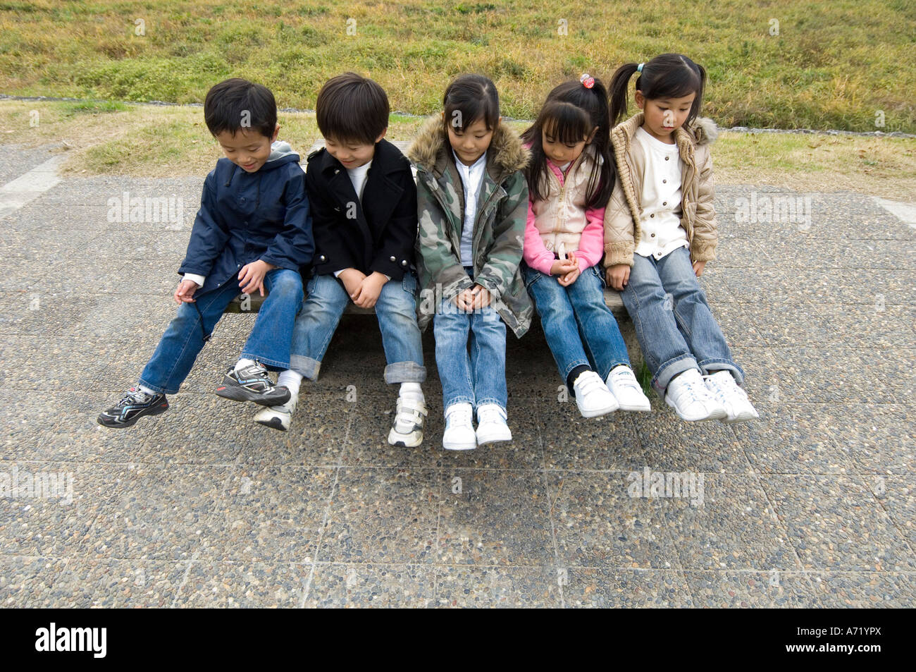 Children sitting in a row Stock Photo - Alamy