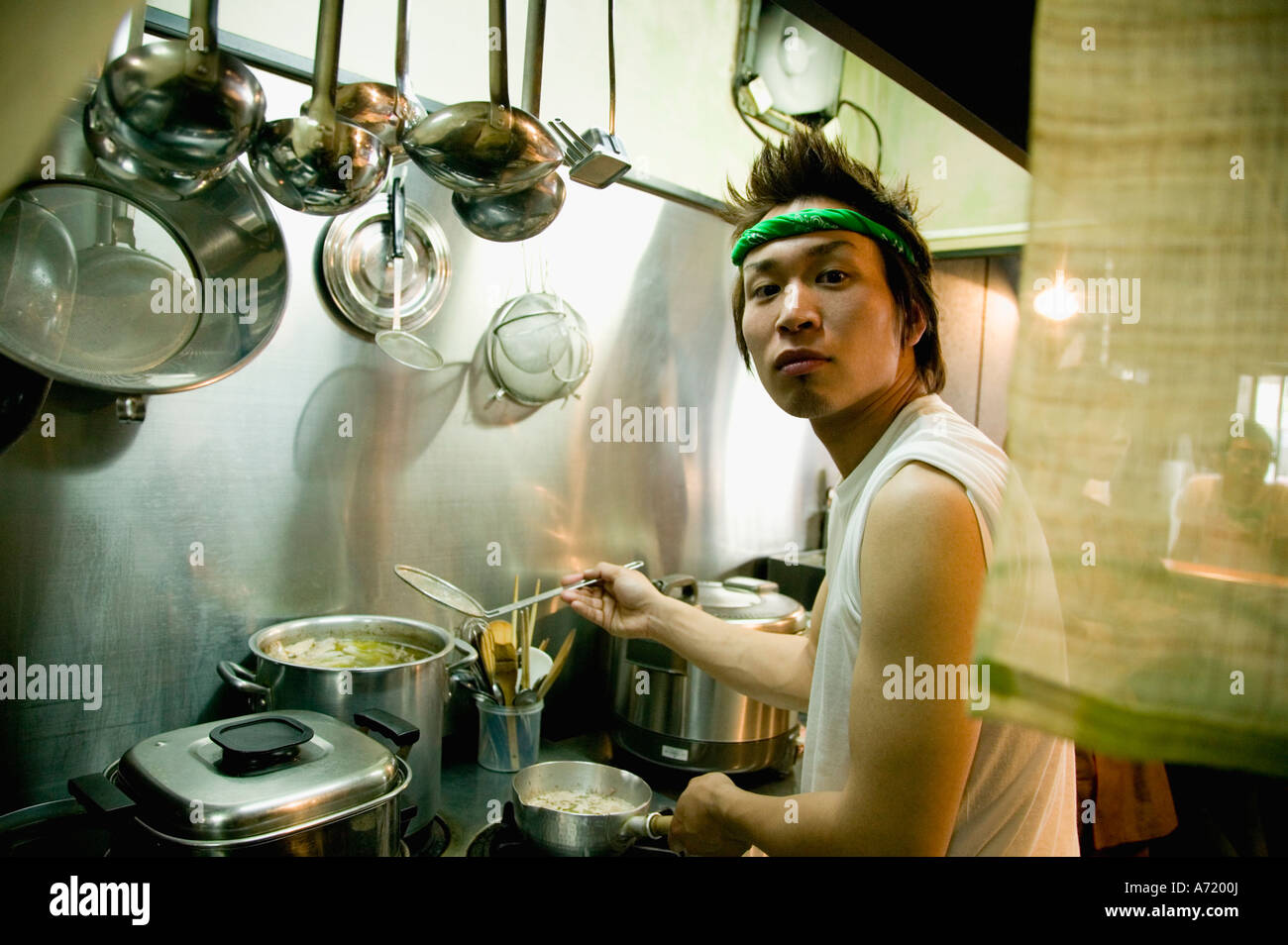 Young man cooking in restaurant kitchen Stock Photo - Alamy