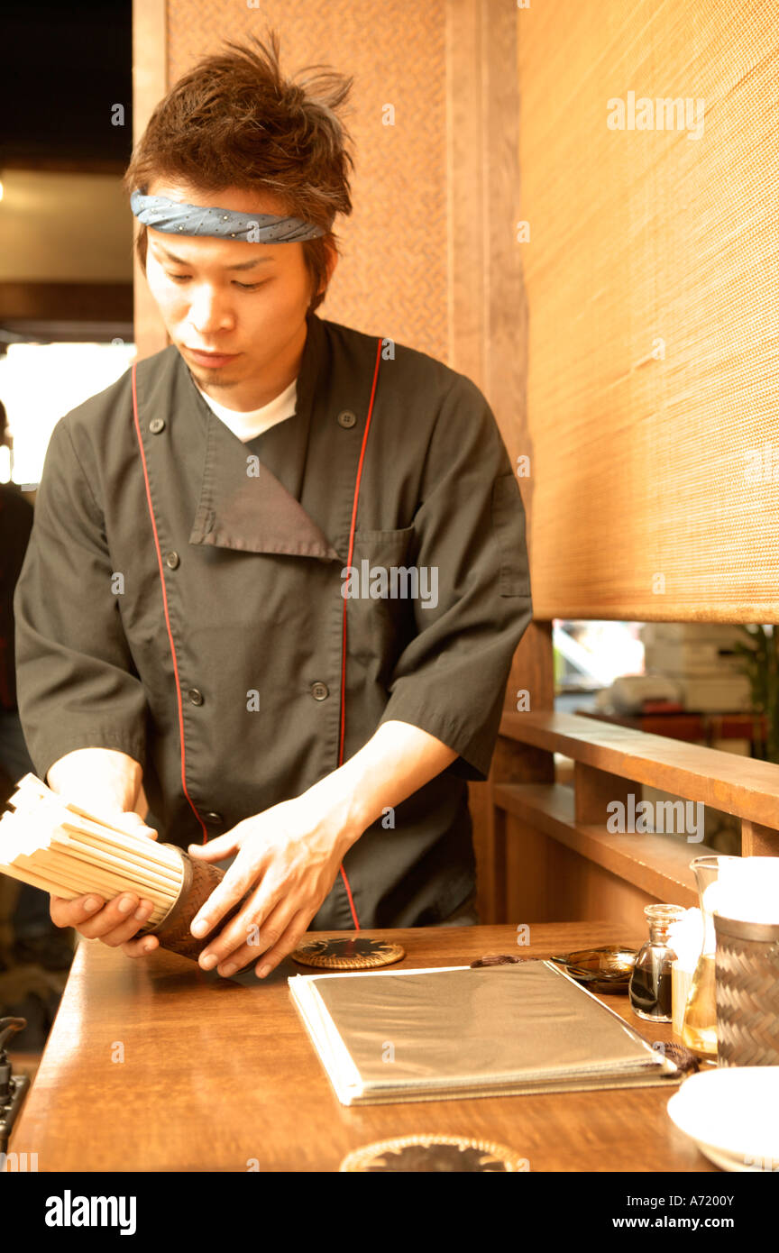 Young man setting chopsticks Stock Photo - Alamy