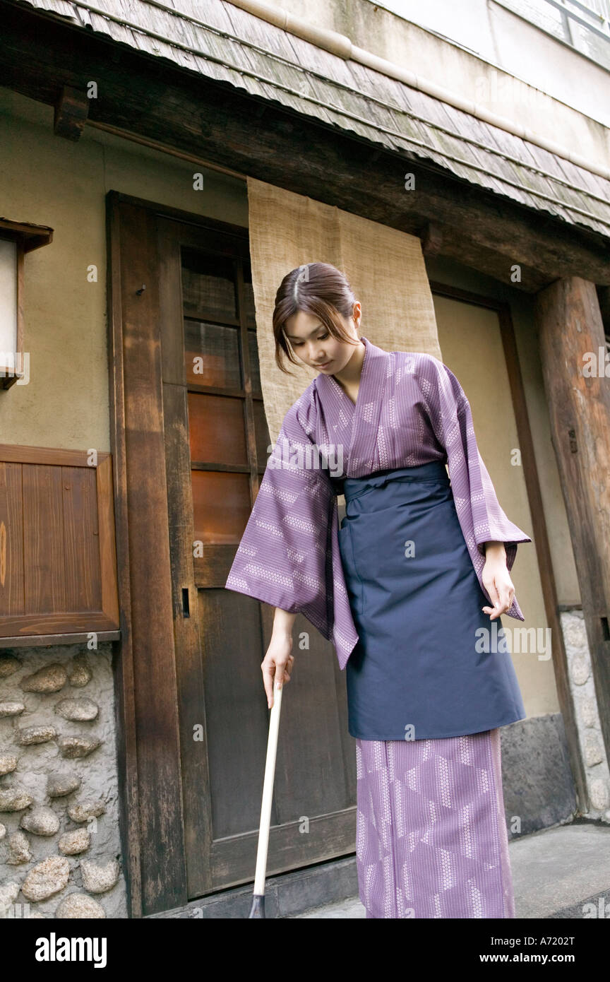 Young woman cleaning with broom Stock Photo - Alamy
