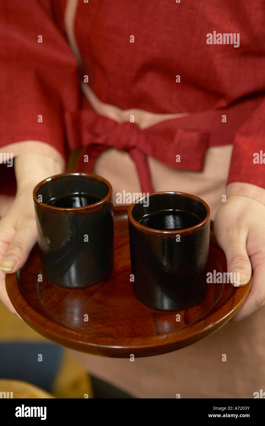 Young woman carrying a tray of tea Stock Photo - Alamy