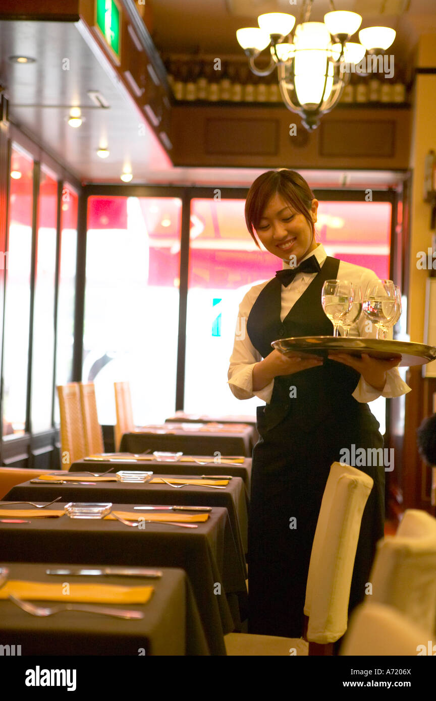 Waitress holding tray with glasses of water Stock Photo - Alamy