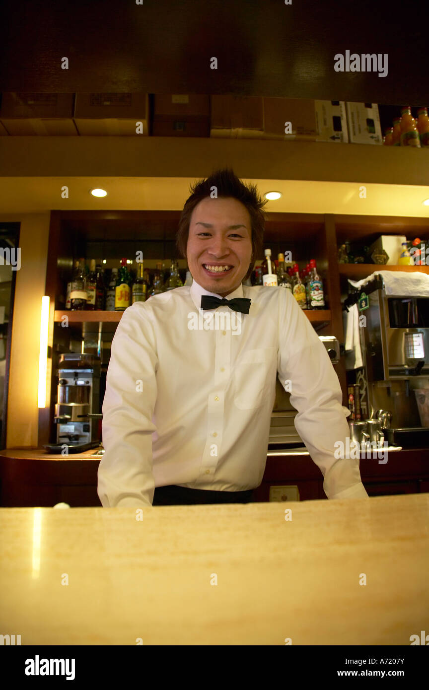 Waiter standing behind bar counter Stock Photo - Alamy