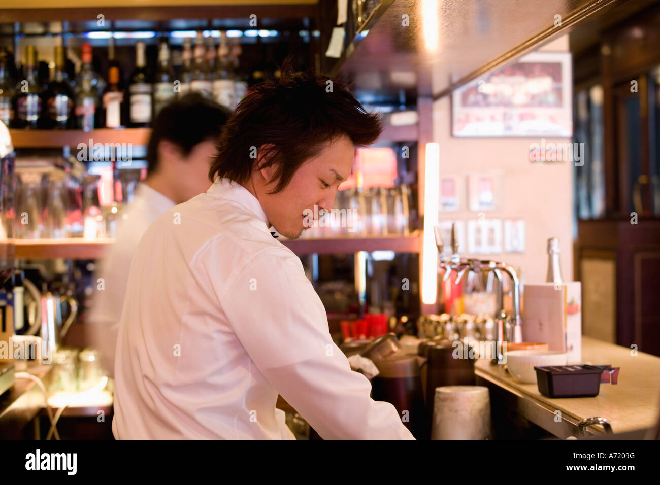 Waiter standing behind bar counter Stock Photo - Alamy