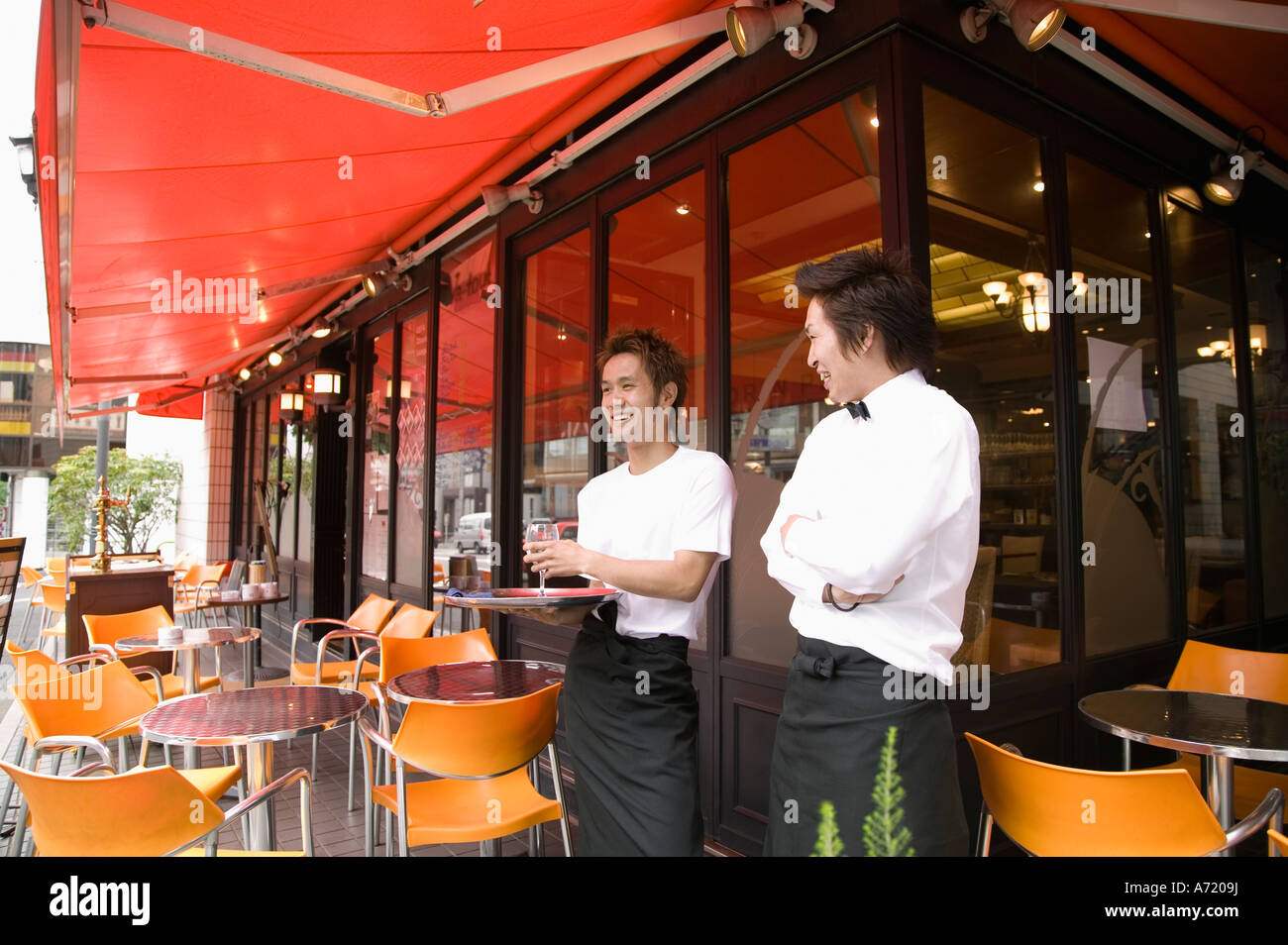 Two waiters standing in front of coffee shop Stock Photo - Alamy