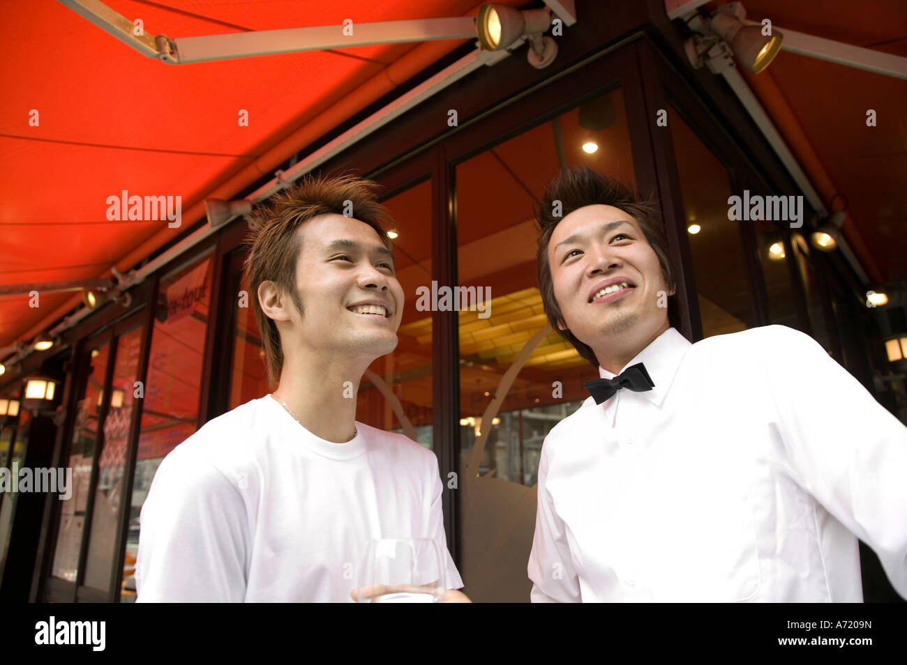 Two waiters standing in front of coffee shop Stock Photo - Alamy