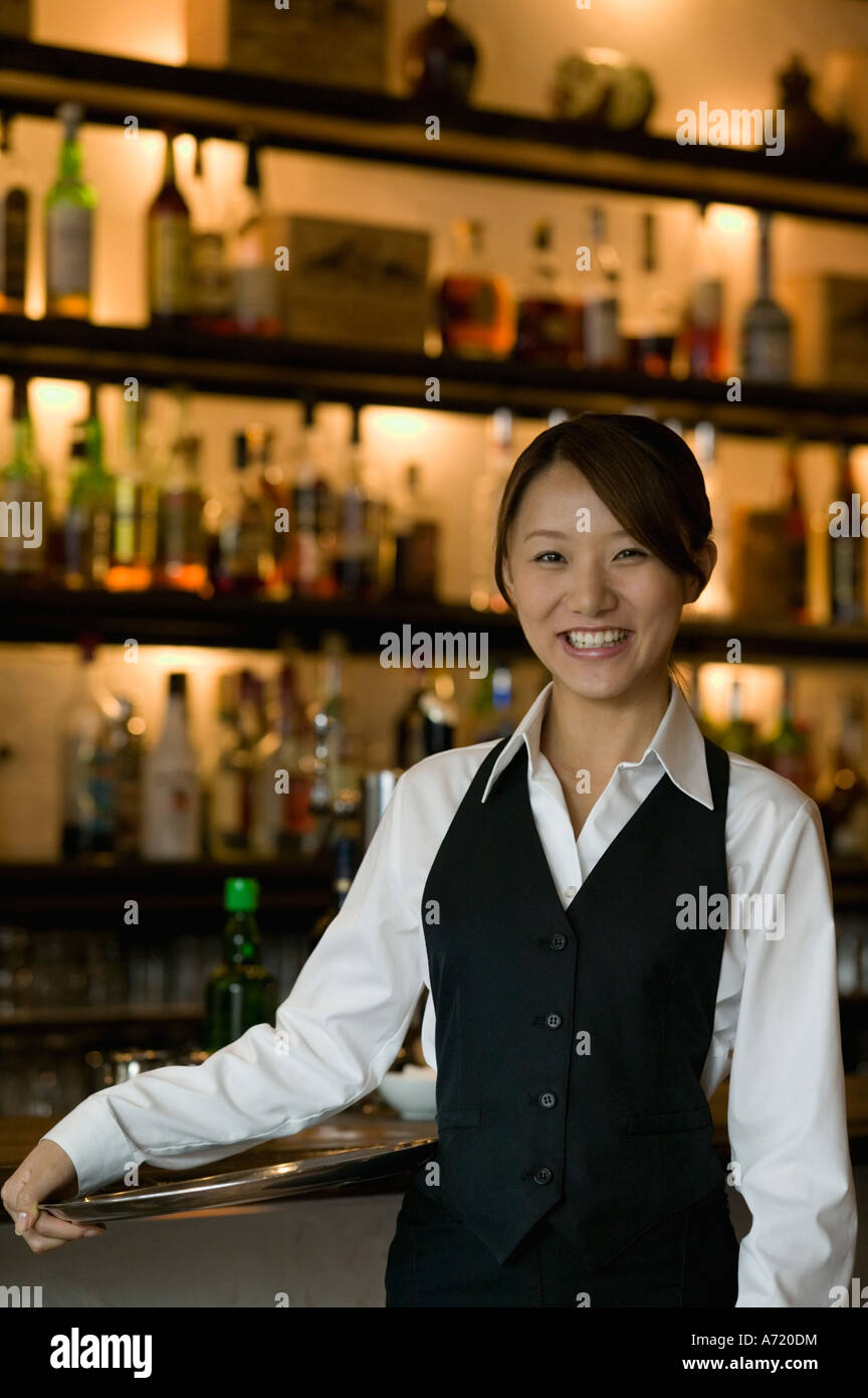 Waitress standing in front of bar counter Stock Photo - Alamy