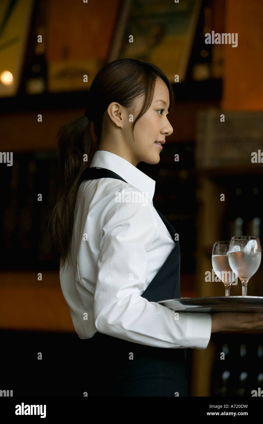 Waitress holding tray with glasses of water Stock Photo - Alamy