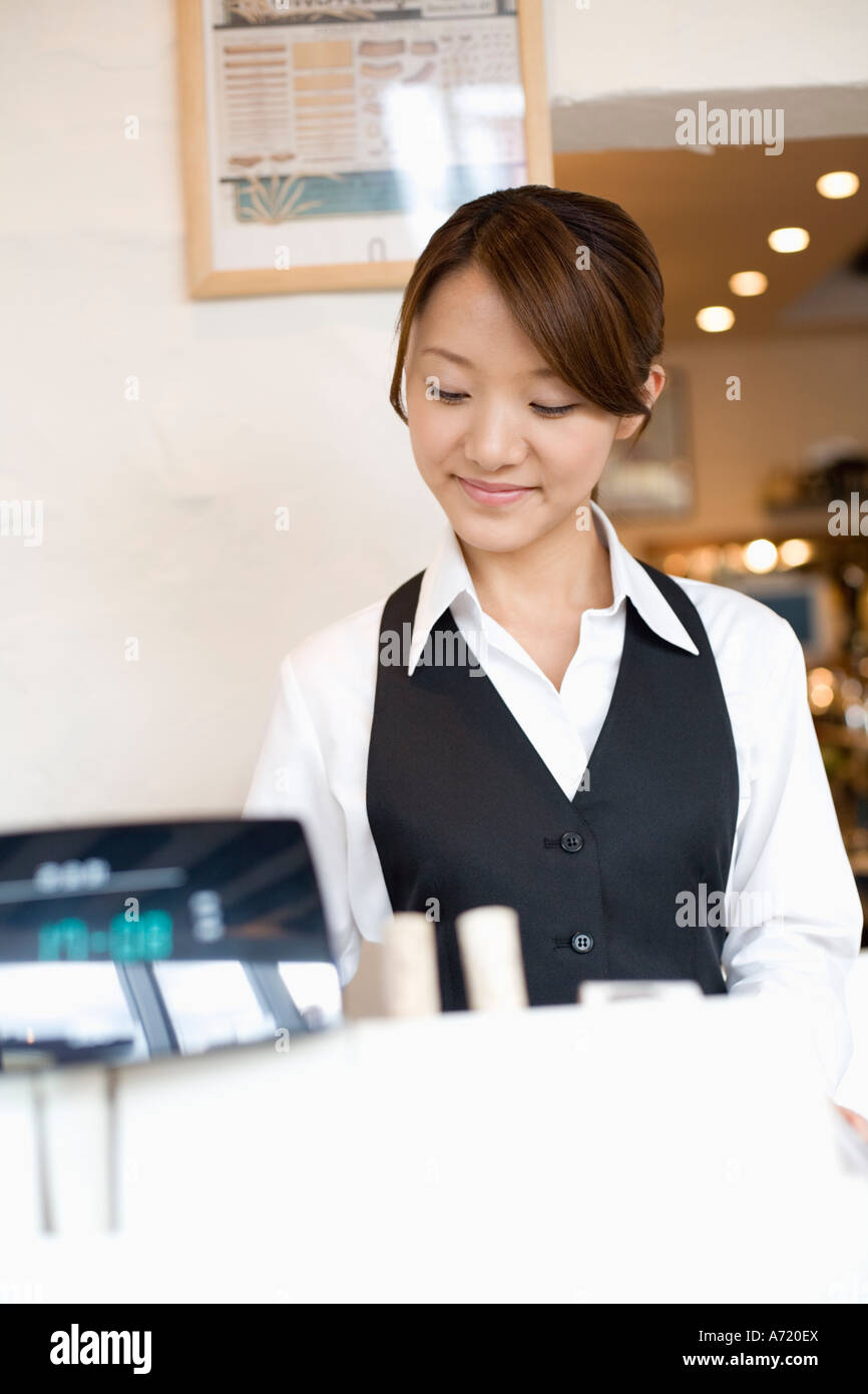 Cashier at checkout counter Stock Photo - Alamy