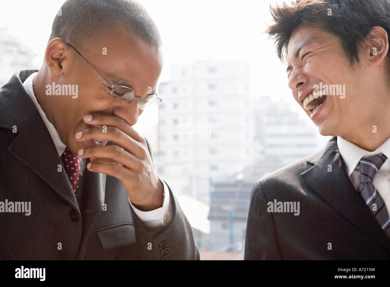 Two businessmen talking and laughing Stock Photo - Alamy