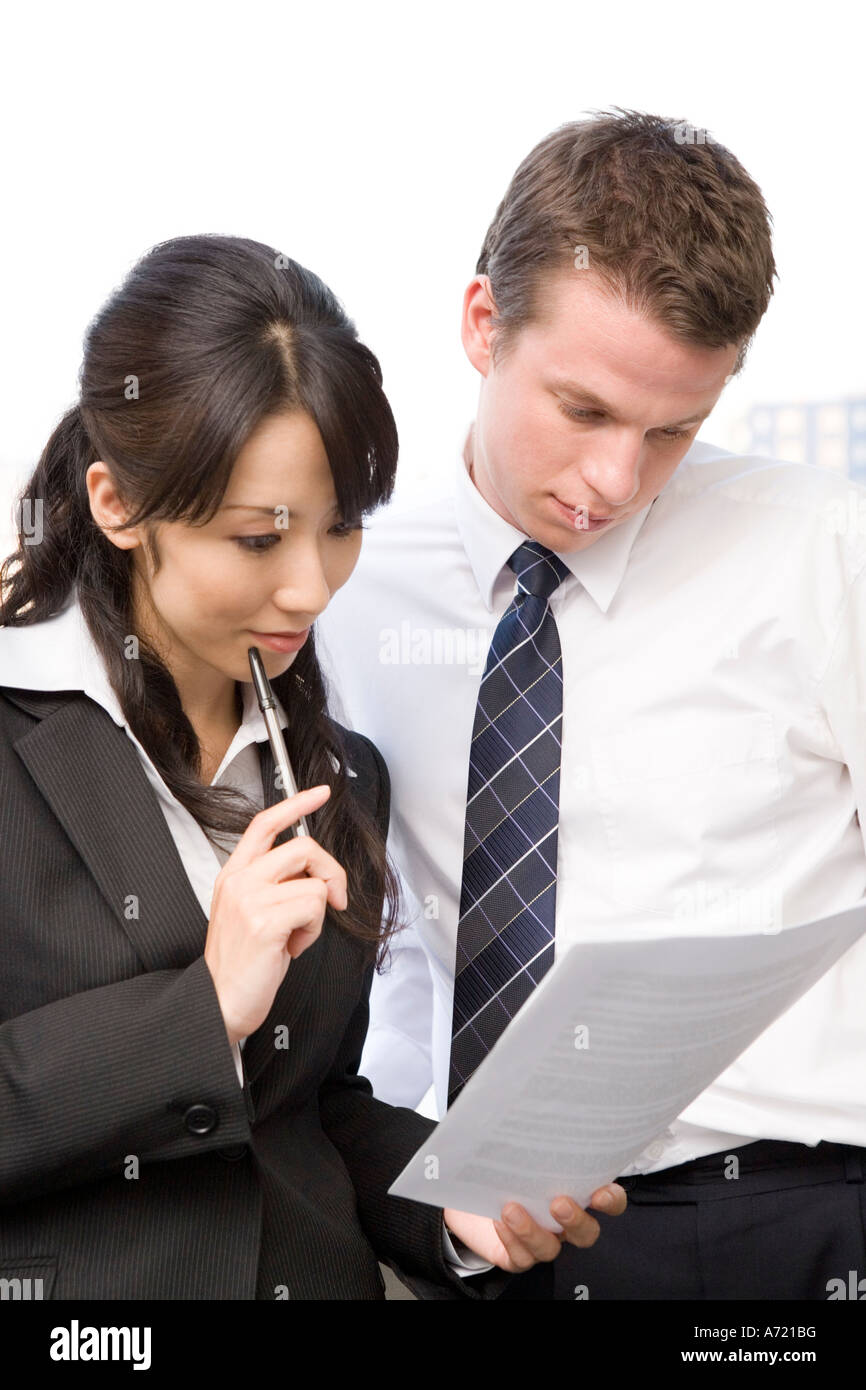 Two business people looking at document Stock Photo - Alamy