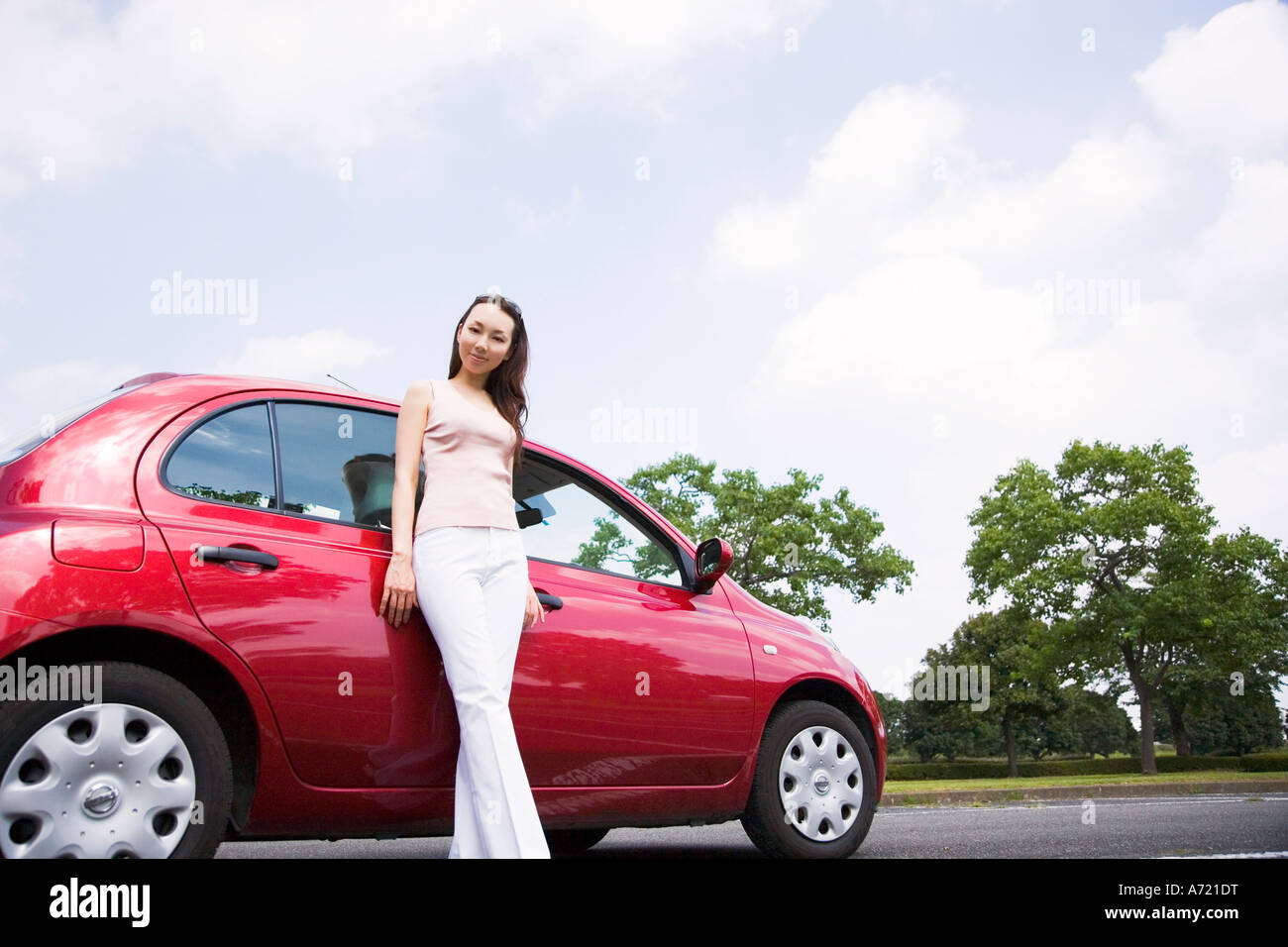 Young woman standing beside car Stock Photo - Alamy
