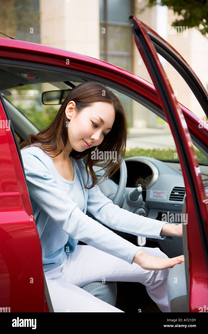 Young woman getting out of car Stock Photo - Alamy