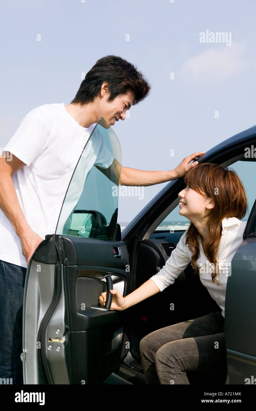 Young couple getting out of car Stock Photo - Alamy